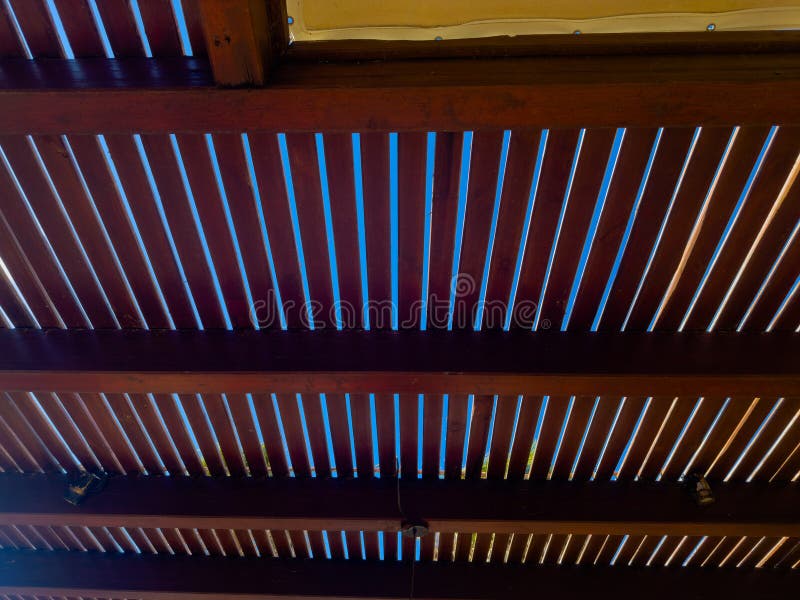 Wooden Ceiling with Blue Light Filtering through Slats Creates a ...