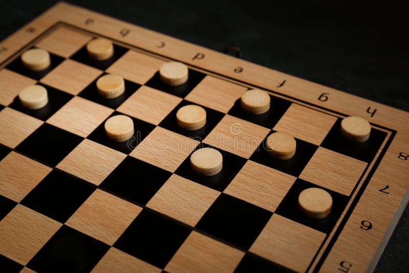 Wooden Checkerboard with Game Pieces on Black Table, Closeup Stock ...