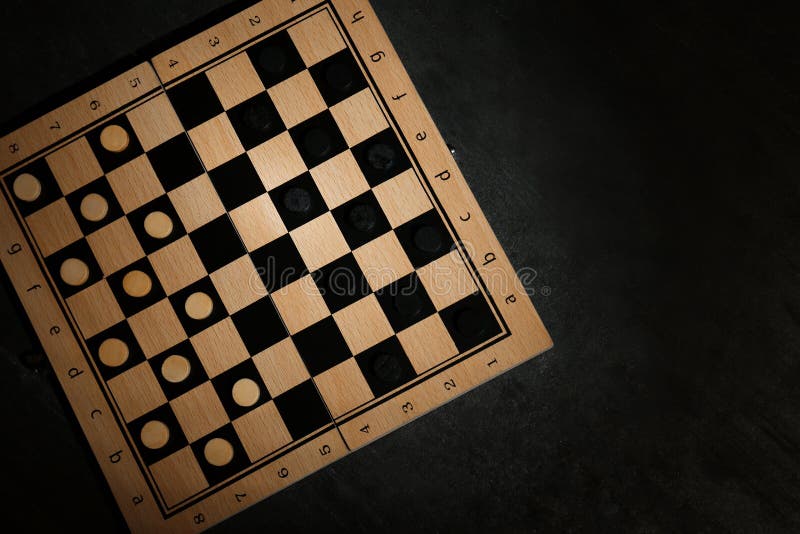Wooden Checkerboard with Game Pieces on Black Table, Top View. Space ...