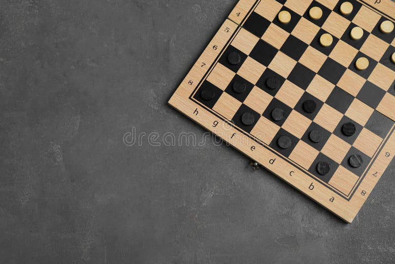 Wooden Checkerboard with Game Pieces on Grey Table, Top View. Space for ...