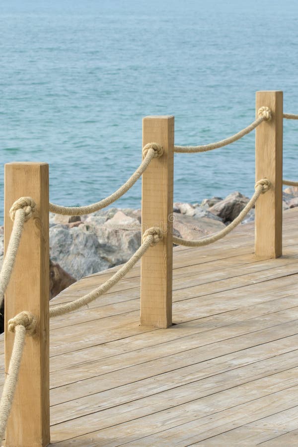 Wooden Columns Connected with Ropes. View of the Blue Sea Stock Photo ...