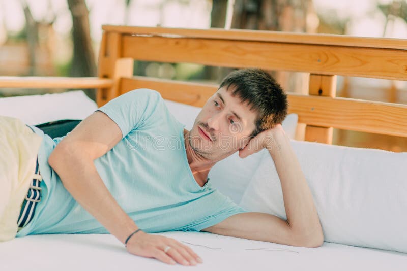 On a Wooden Couch Resting Man Stock Image - Image of pillow, green ...