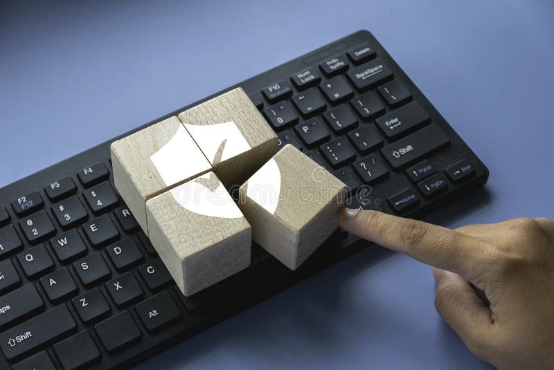 Wooden Cube with Shield Logo and Check Mark Over a Computer Keyboard ...