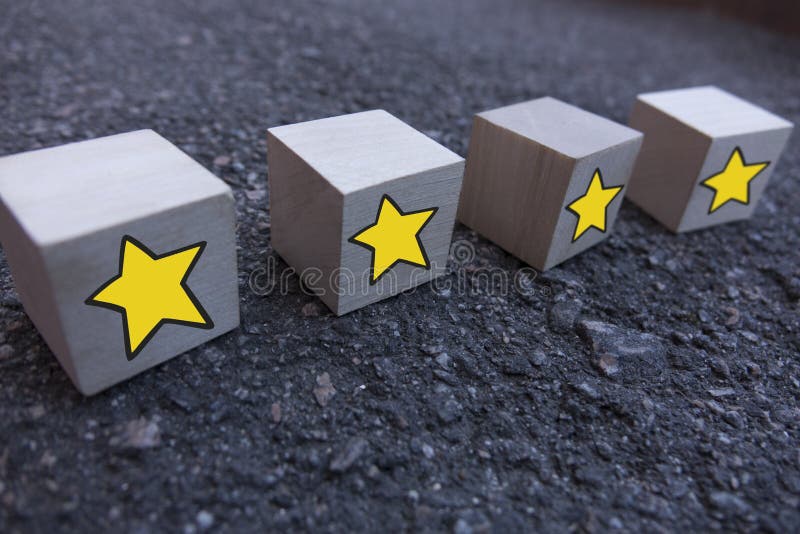 4 Wooden Cubes with a Pattern of a Yellow Star Standing on Top of Each ...