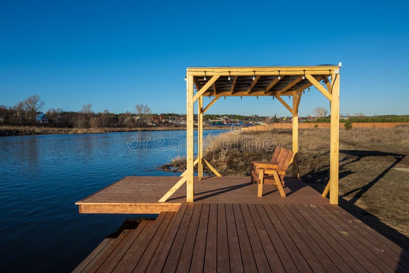A Wooden Deck with a Bench and a Bench on the Edge of the Water Stock ...