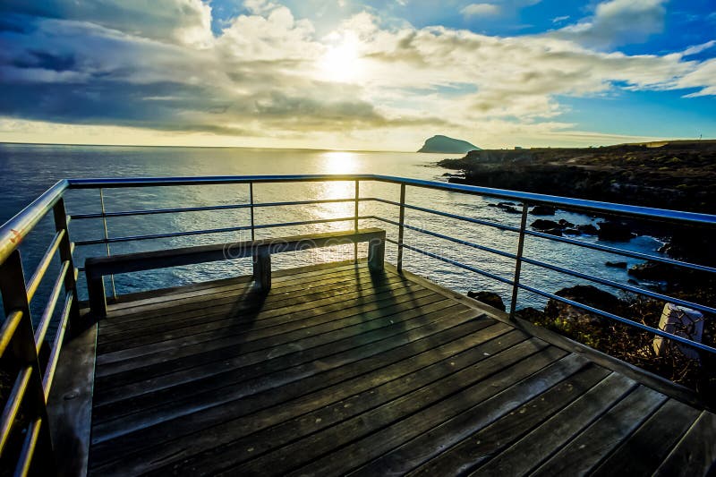 A Wooden Deck Overlooking the Ocean with a Bench and Railing Stock ...