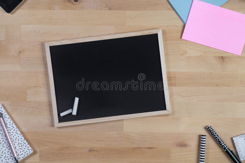 Wooden Desk with Chalkboard, Notepad and Pens. Top View Stock Photo ...
