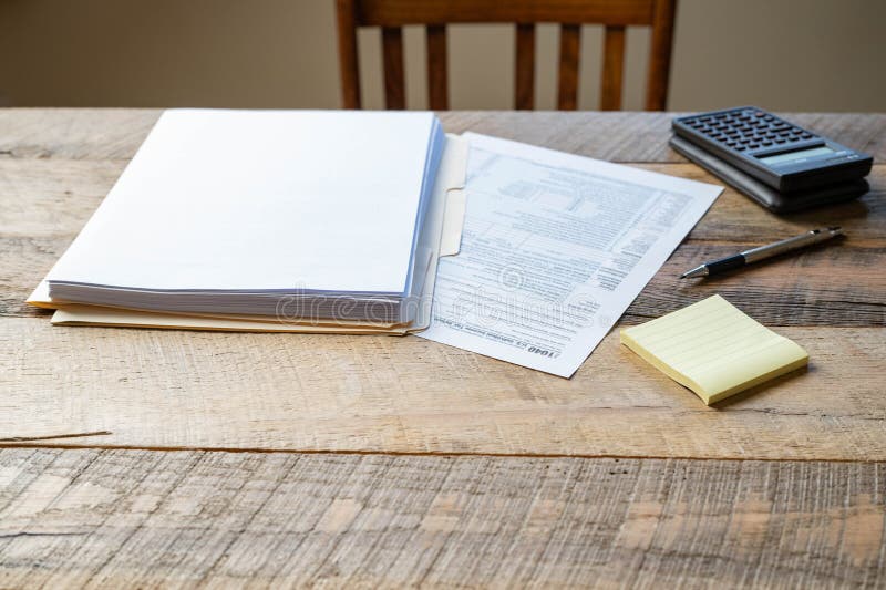 Wooden Desk with Stack of Papers, a Tax Form, Note Pad, Pen, and ...