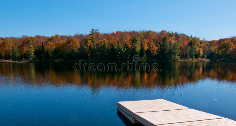 Wooden dock on autumn lake stock photo. Image of cottage - 34702292