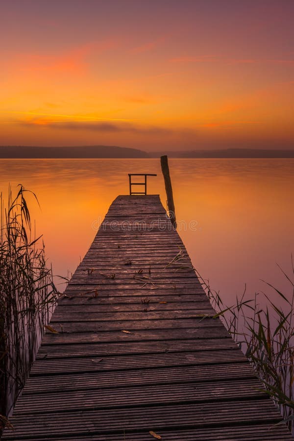 Wooden Dock Over the Smooth Surface of a Lake Under the Beautiful ...