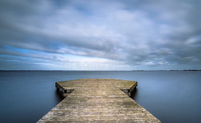 Wooden Dock on the Sea with Long Exposure Under a Cloudy Sky Stock ...