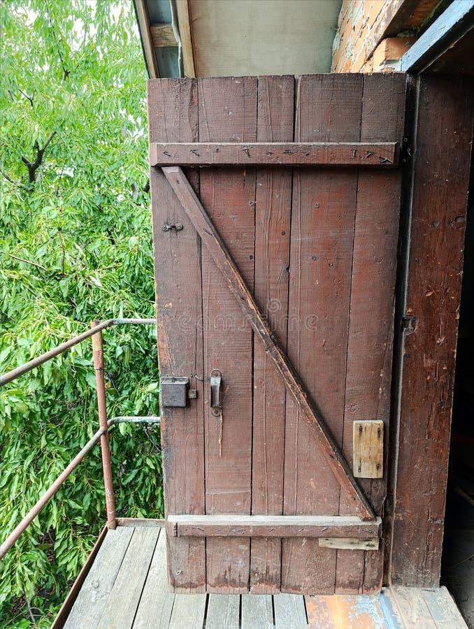 A Wooden Door on the Side of a Building with a Metal Railing Stock ...