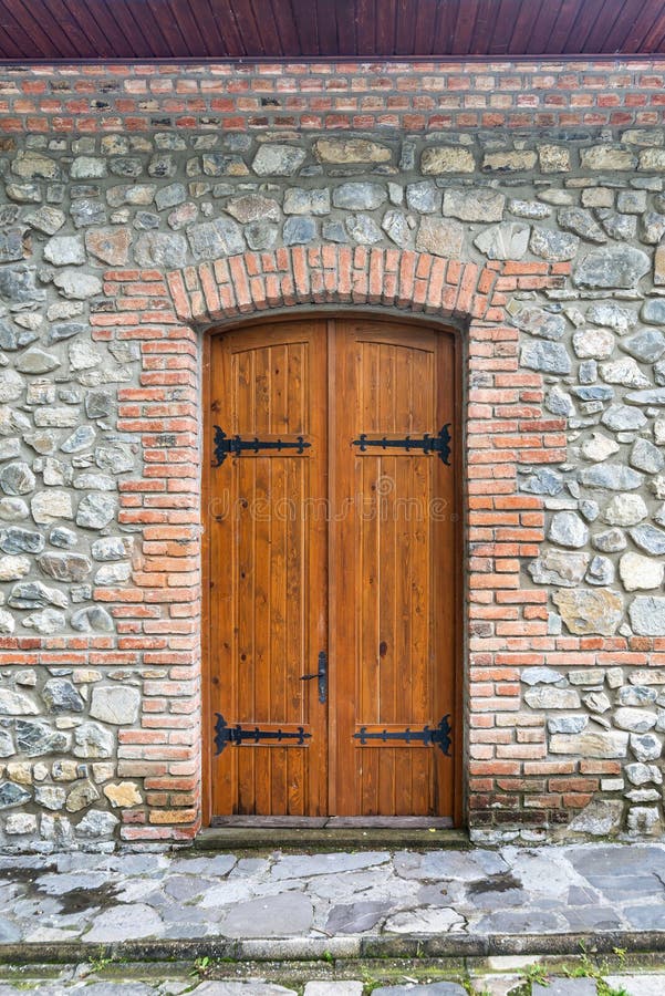 Wooden Double Doors, with Black Iron Hinges, are Set within an Arched ...
