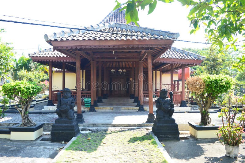 Wooden House in Classic Style with Two Statues in Front of the House ...