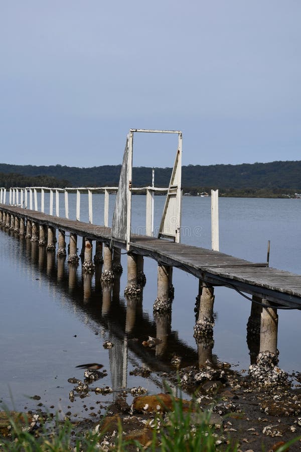 A Wooden Jetty Reflected in a Bay Stock Photo - Image of hills ...