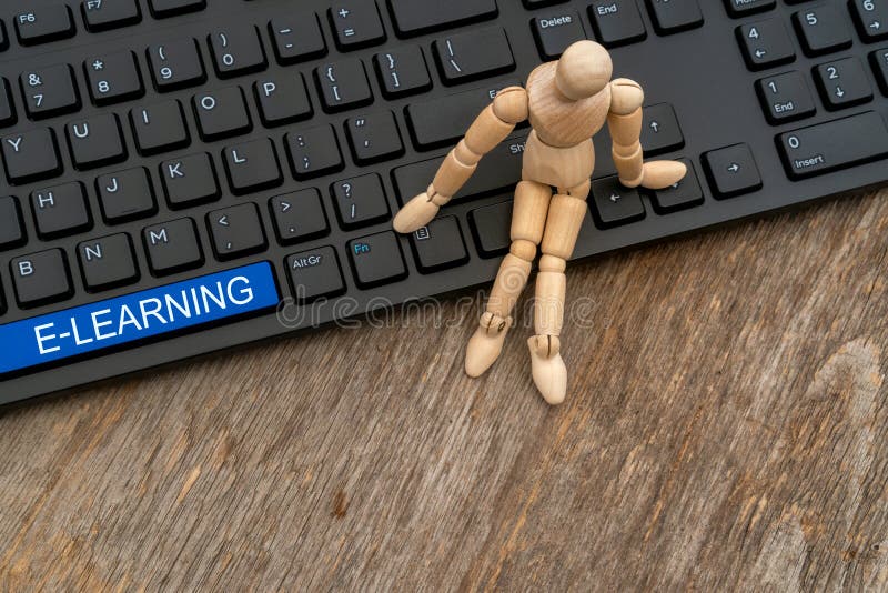 Wooden Man Sitting on the Keyboard with E-learning Button Stock Photo ...