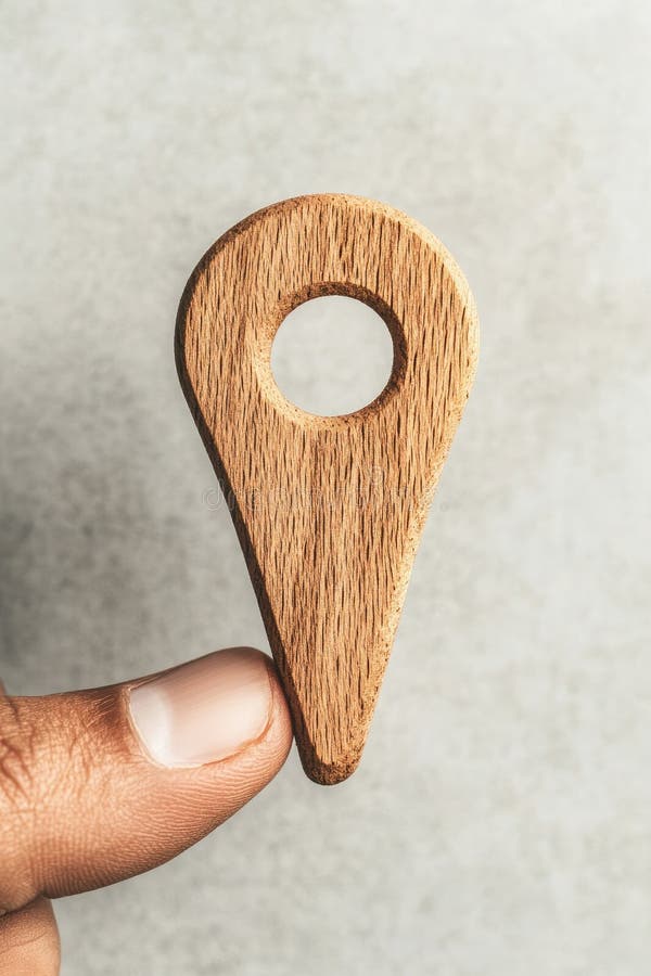 Wooden Map Pointer Held by Finger Against Gray Surface Displaying ...