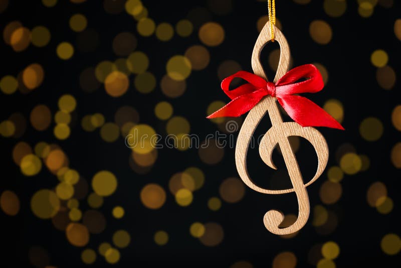 Wooden Music Note with Red Bow Hanging on Black Background with Blurred ...