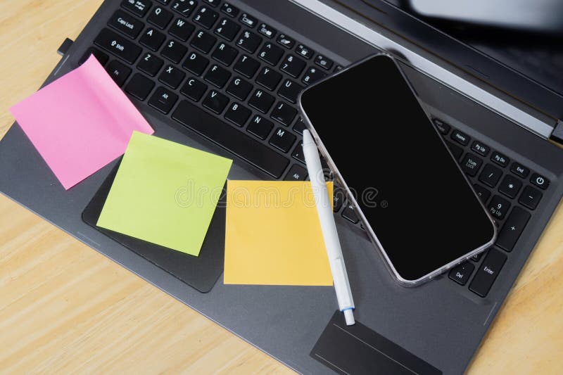 Wooden Office Table with Pen, Note Papers and Smartphone on Laptop ...