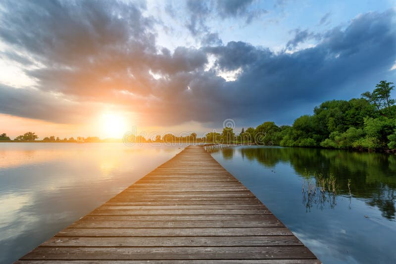 Wooden Path Bridge Over Lake at Stormy Dramatic Sunset Stock Image ...
