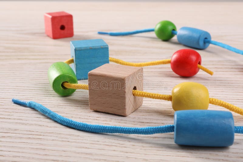 Wooden Pieces and String for Threading Activity on Light Table, Closeup ...
