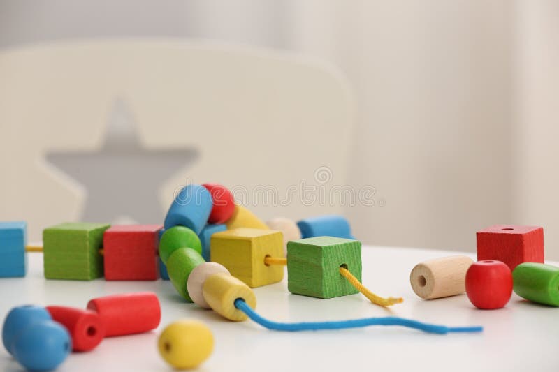 Wooden Pieces and String for Threading Activity on White Table. Motor ...
