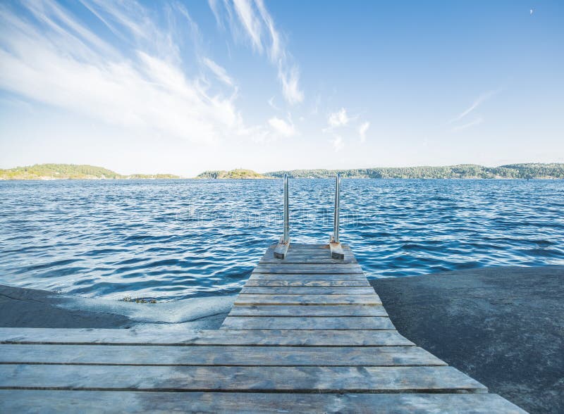 Wooden Pier on the Deep Blue Water Stock Photo - Image of wooden, water ...