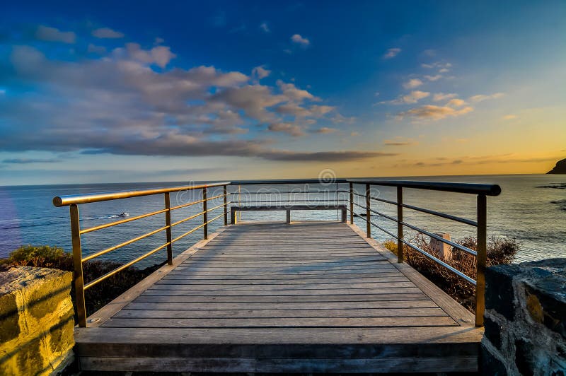 A Wooden Pier with a Railing Overlooking the Ocean Stock Photo - Image ...