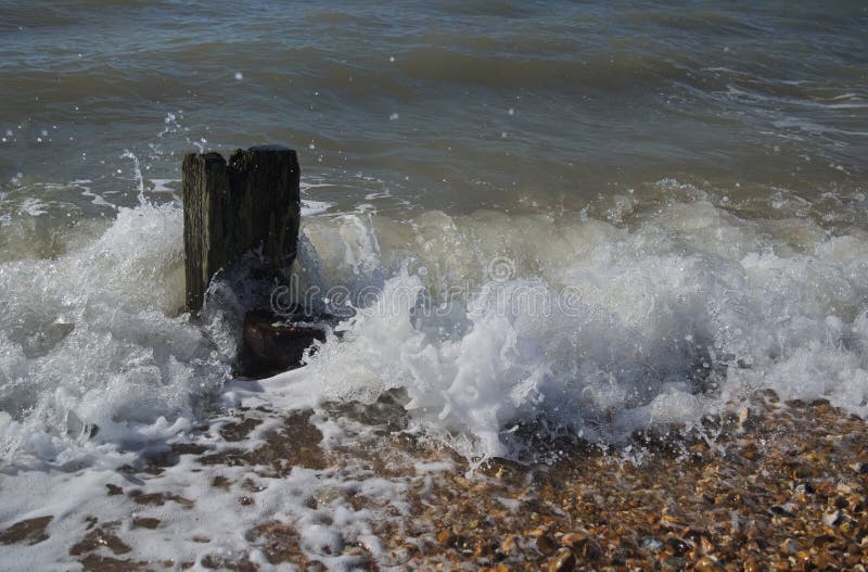 Wooden post meets waves. stock image. Image of breezy - 141110561