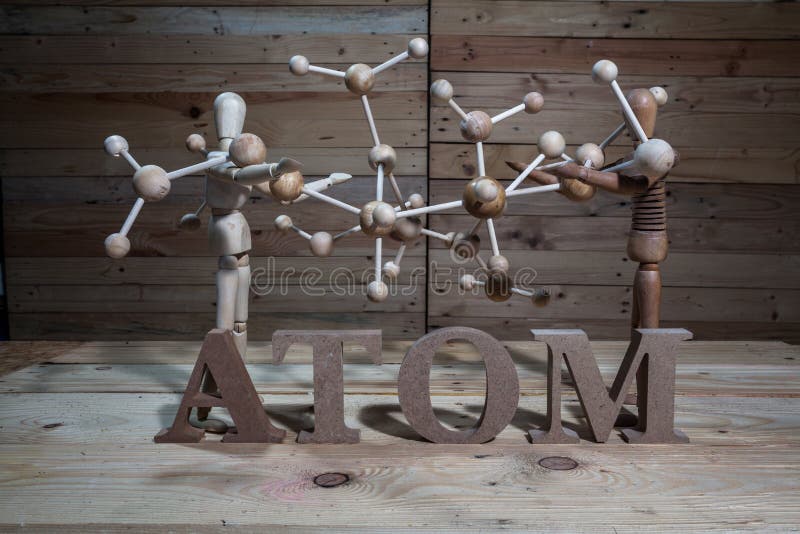 Wooden Puppets with Atom Word Stock Image - Image of atom, word: 124042571