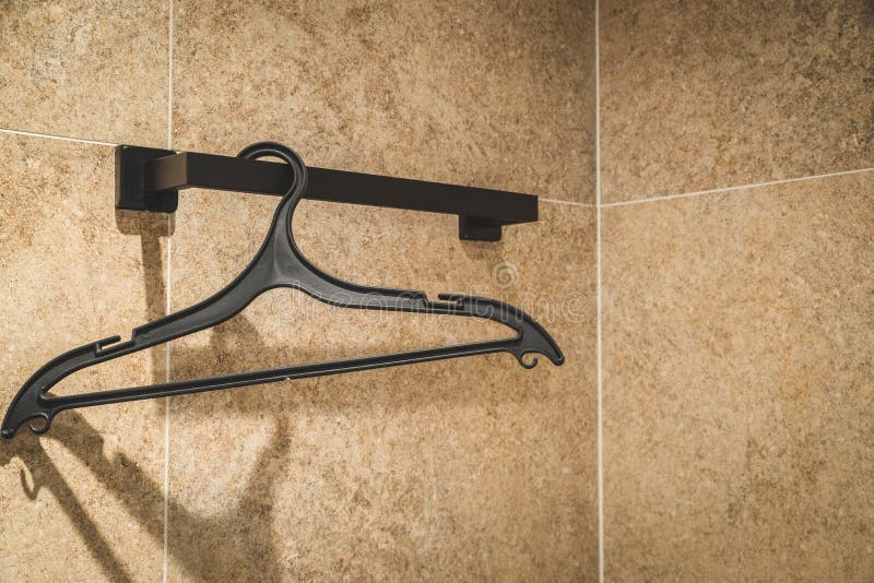 Black Hanger Hanging Empty. Wooden Rack with Hangers Near Grey Wall ...