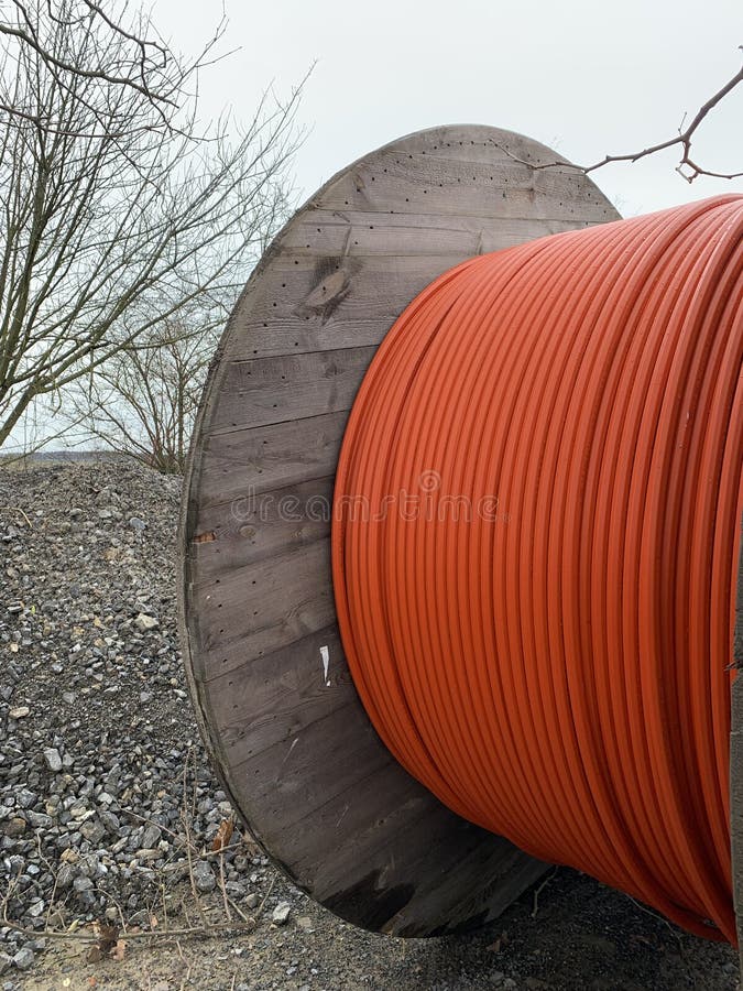 A Wooden Reels with an Orange Cable on a Construction Site. Close Up ...