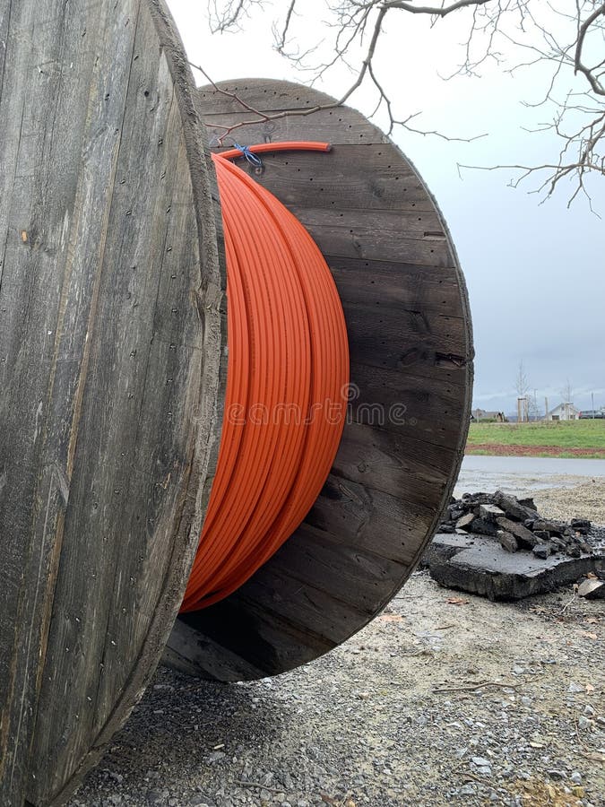 A Wooden Reels with an Orange Cable on a Construction Site. Side View ...