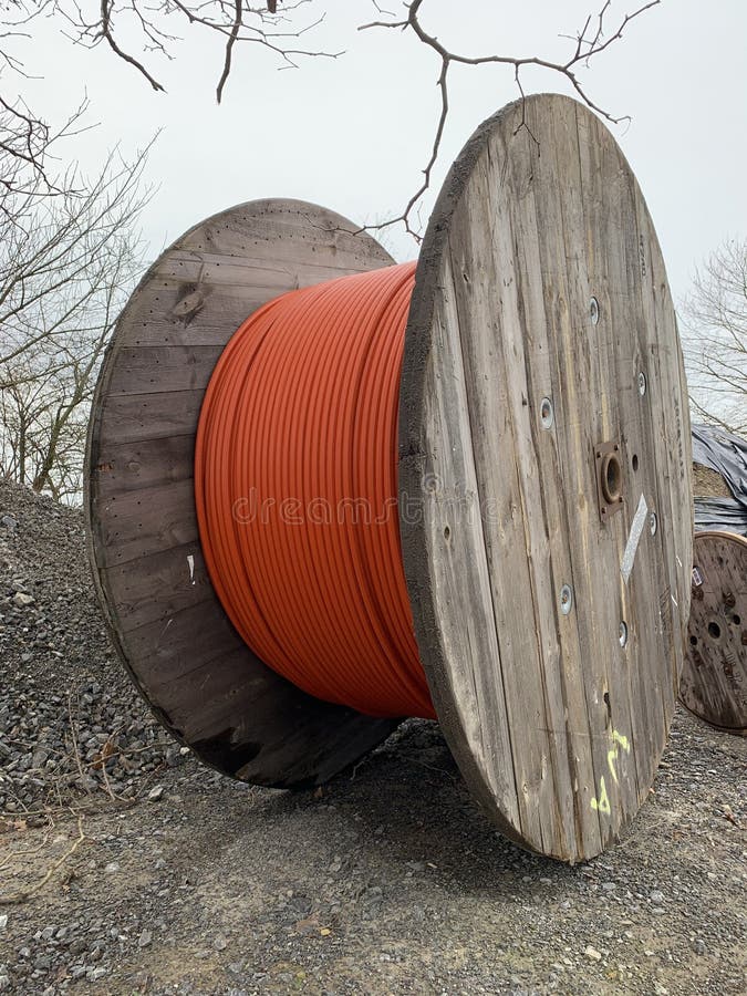 A Wooden Reels with an Orange Cable on a Construction Site. Side View ...