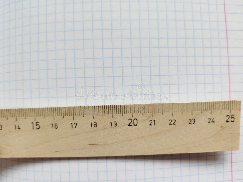 Wooden Ruler with Metric System Rests on a White Checkered Exercise ...