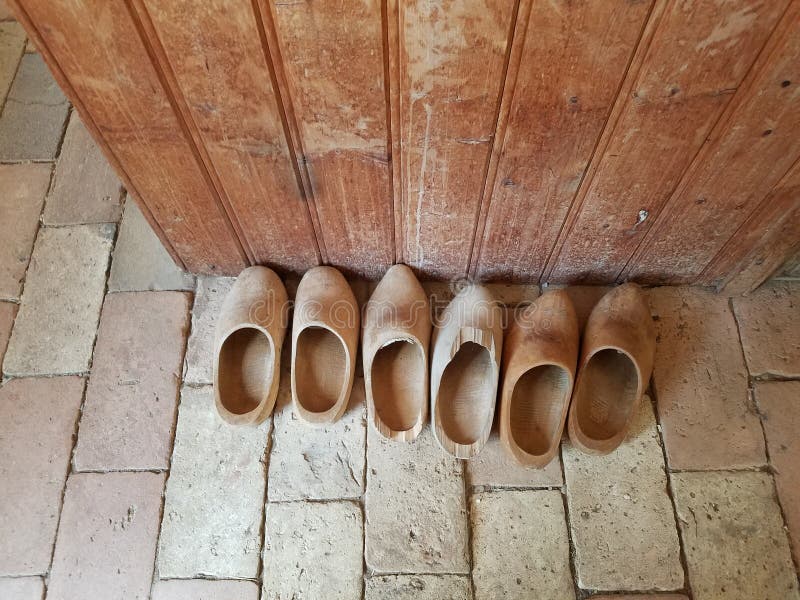 Wooden Shoes on Brick Stone Floor by a Wooden Wall Stock Image - Image ...
