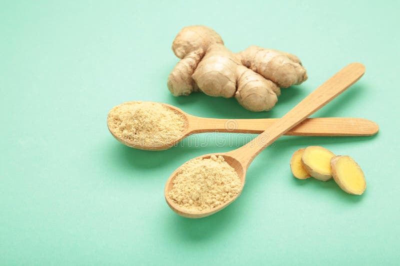 Wooden Spoon with Dried Ginger Powder and Fresh Ginger Root on Mint ...
