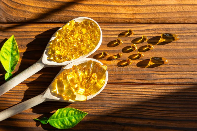 Wooden Spoons Filled with Yellow Capsules. Two Wooden Spoons are Filled ... Wooden Spoons Filled with Yellow Capsules. Two Wooden Spoons are Filled ...