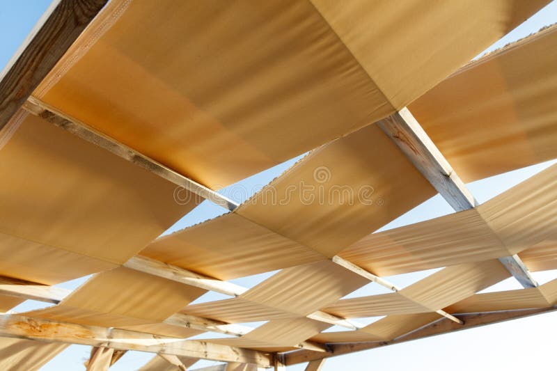 A Wooden Structure with a Tan Canopy Has a Blue Sky in the Background ...
