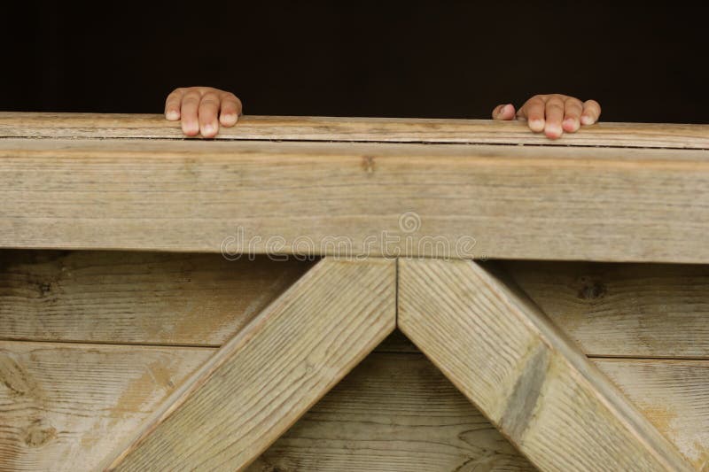 A Wooden Structure with Two Hands Peeking Out from Behind it Stock ...