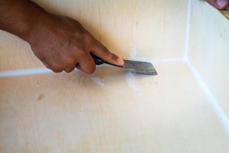 Wooden Surface and Hand Using Scraper Tool with White Paint Scraped ...