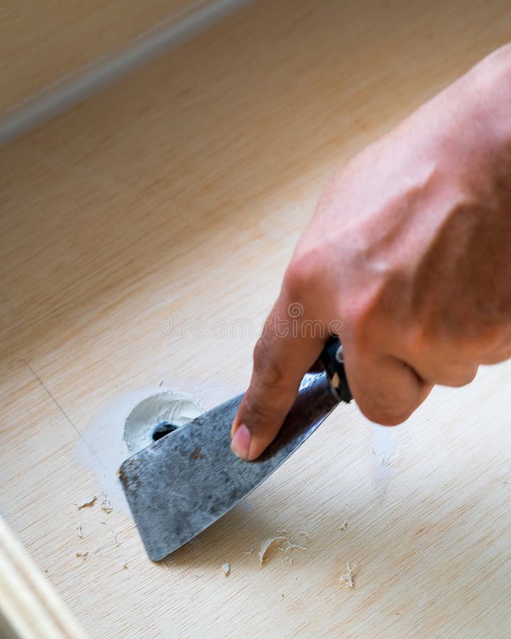 Wooden Surface and Hand Using Scraper Tool with White Paint Scraped ...