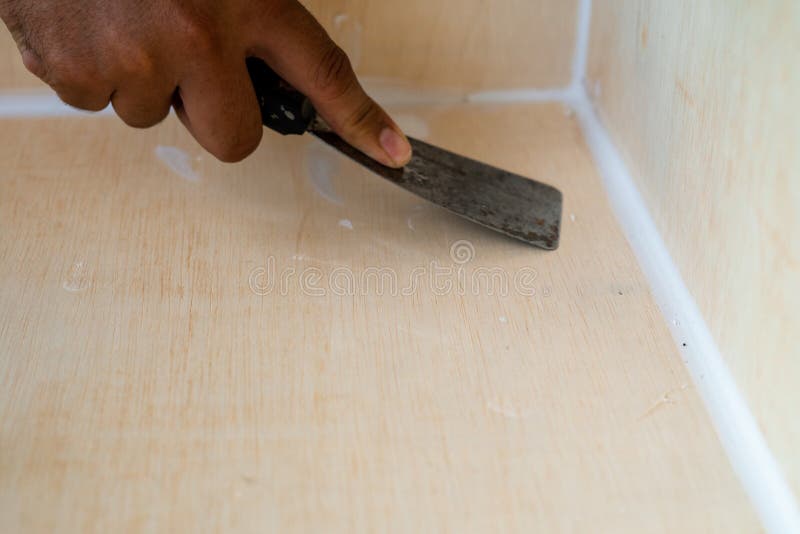 Wooden Surface and Hand Using Scraper Tool with White Paint Scraped ...