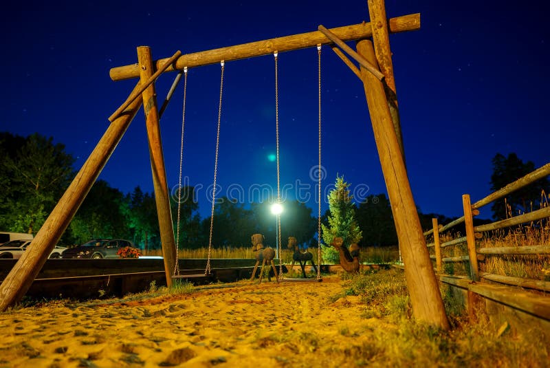 Wooden swing at night stock image. Image of hanging - 255556703