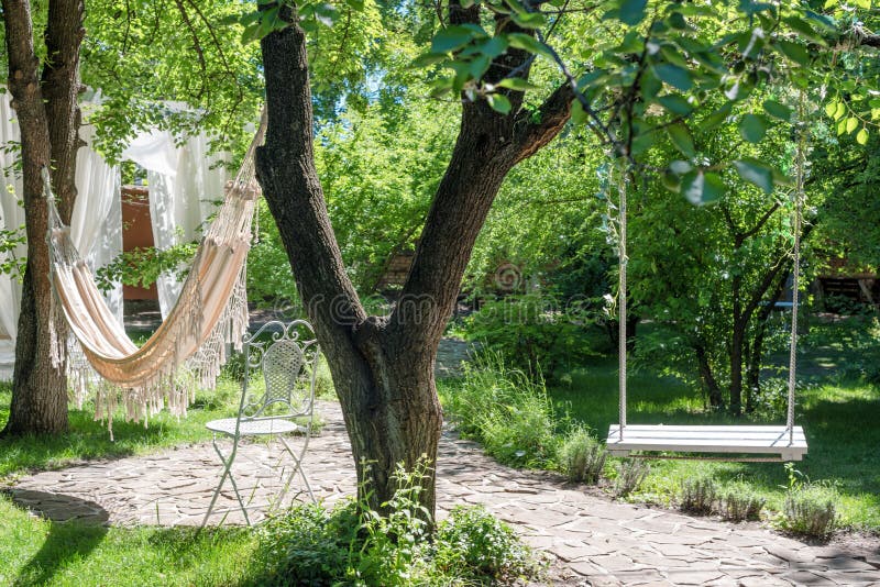 Wooden Swing on Ropes and Hammock Under the Big Tree in the Garden ...