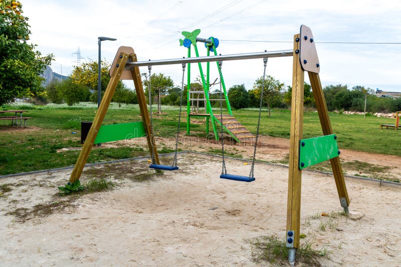 Wooden Swing Set in a Green Playground Stock Image - Image of modern, outdoors: 359642807