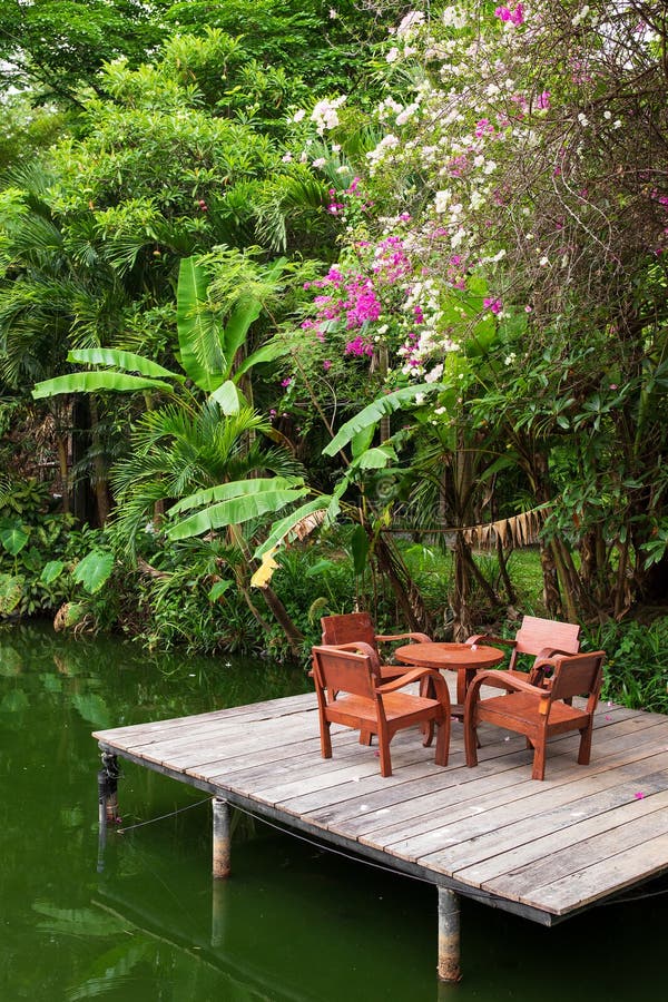 Wooden Table and Four Chairs on a Platform on a Lake in Tropical Jungle ...