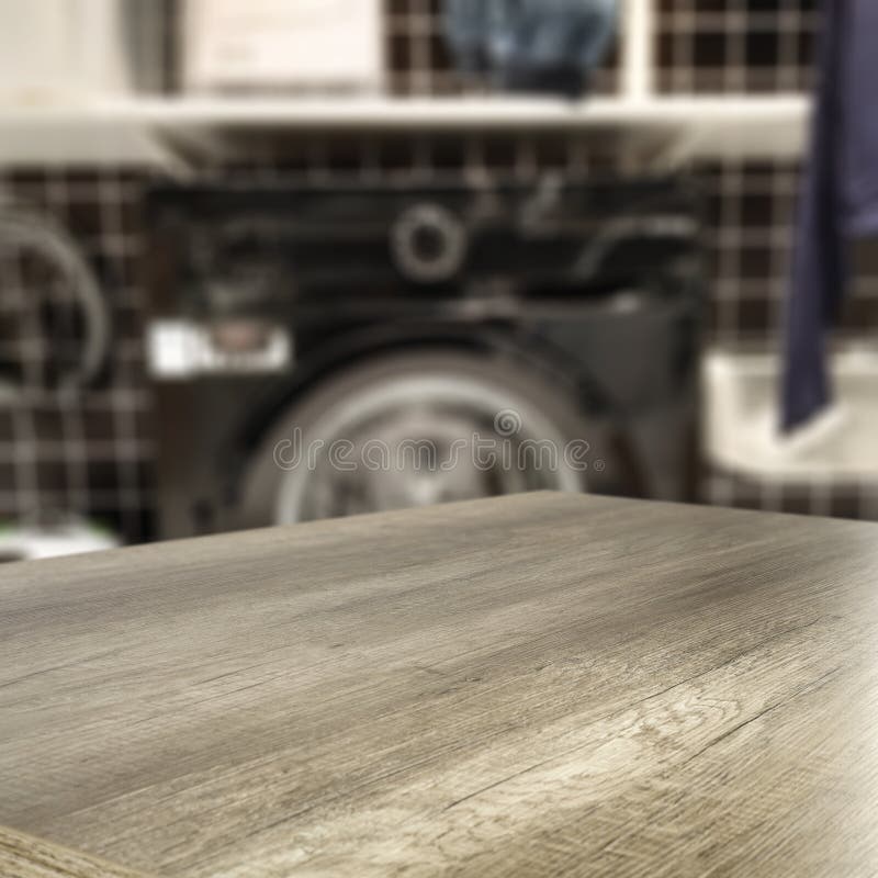 A Wooden Table Surface and Blurred Washing Machine Surrounded by Dark ...