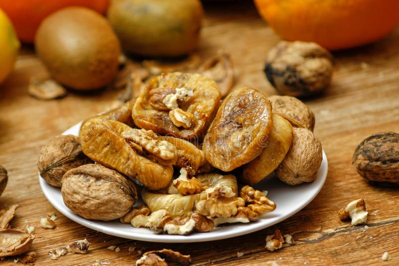 Dried Fig and Whole and Cracked Walnuts on White Ceramic Plate Stock ...