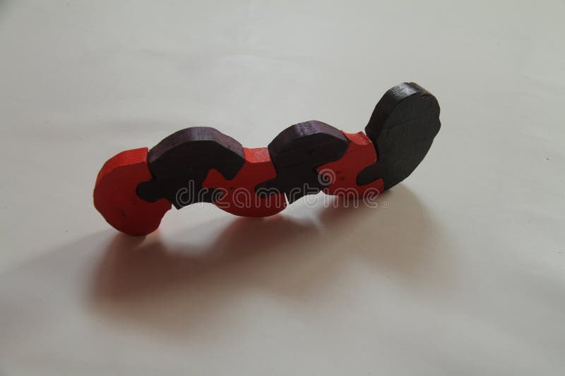 A Wooden Toy Puzzle with a Black and Red Worm Shape is Useful for ... A Wooden Toy Puzzle with a Black and Red Worm Shape is Useful for ...